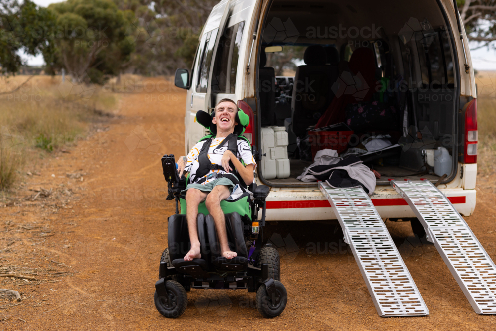 Image of Young man with disability on a wheelchair behind the van with ...