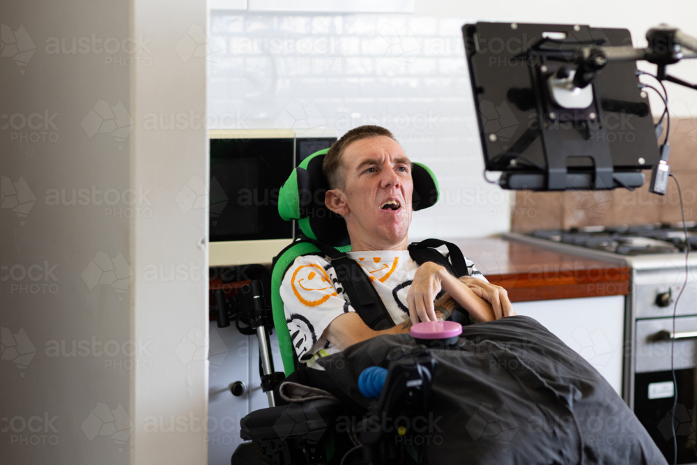Image of Young man with disability on his wheelchair looking on an acc ...