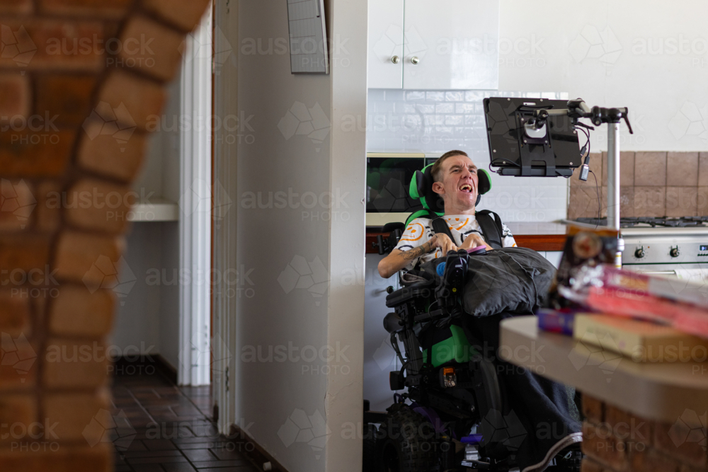 Image of Young man with disability on his wheelchair looking on an acc ...