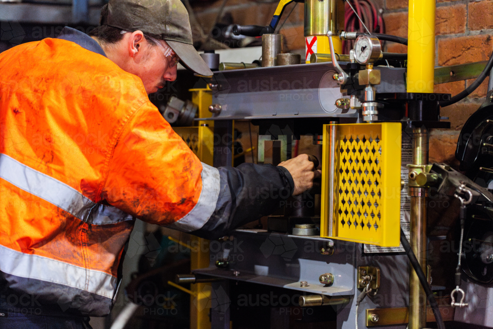 Image of young mechanic tradie using workshop mate press tool ...