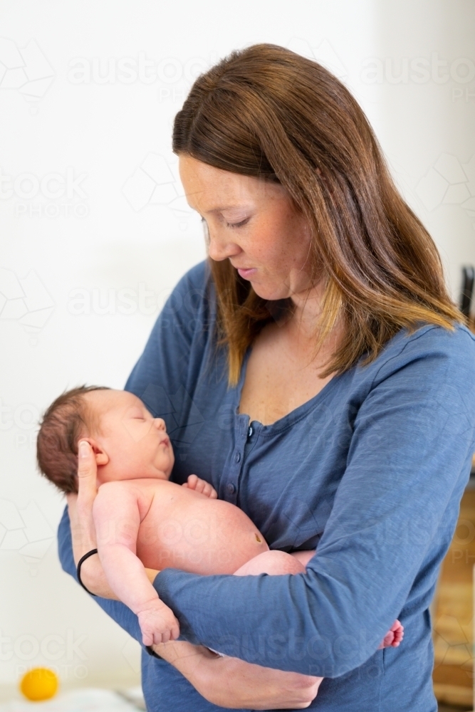 Image of Young mother cradling baby - Austockphoto