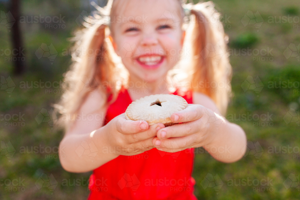 Image of Young person enjoying Christmastime fruit mince pie snack in ...