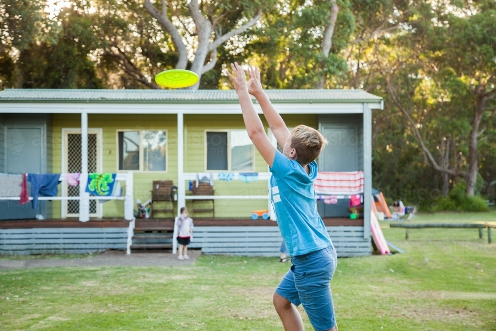 Image of Young person jumping to catch a frisbee - Austockphoto