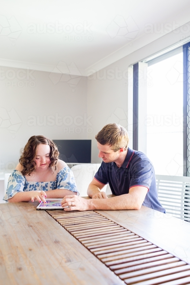 Image of Young person using tablet device with disability worker - two ...