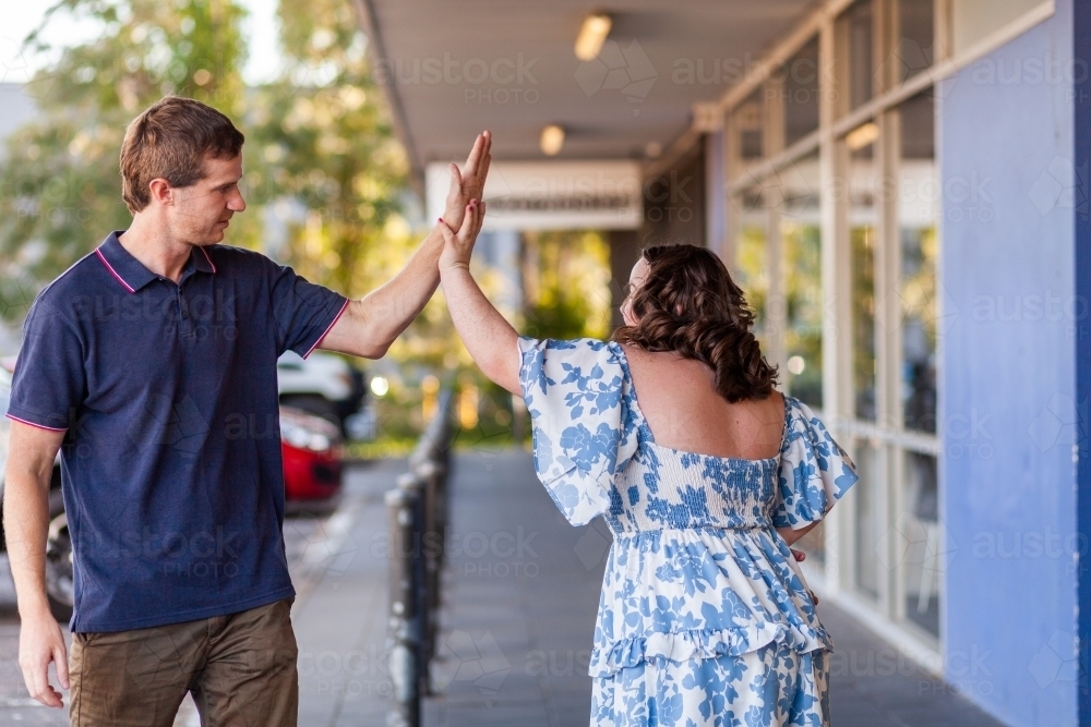 Image of Young person with a disability giving support person a high ...