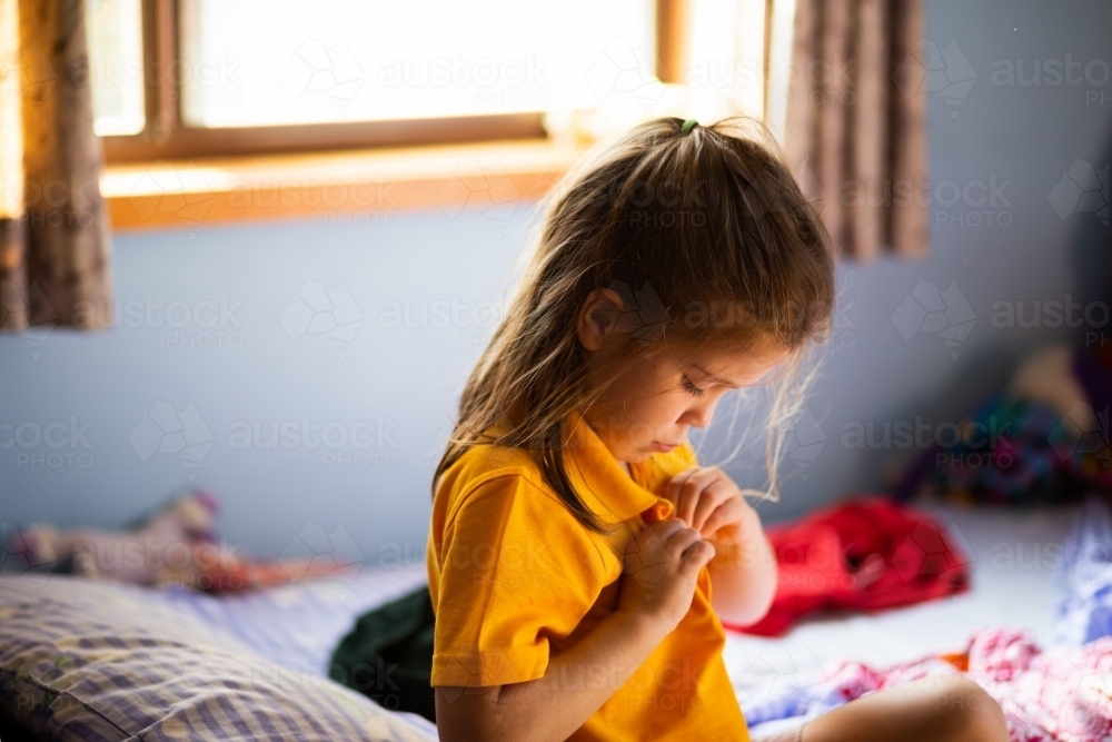 Image of Young school kid getting dressed for school in the morning in ...