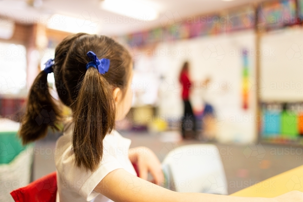Image of Young Student Listening to Teacher in Classroom - Austockphoto
