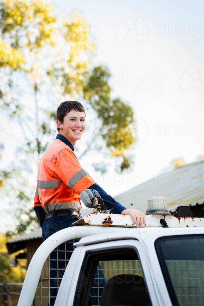 Image of Young teen bloke in high-vis workwear in the back of his ute ...