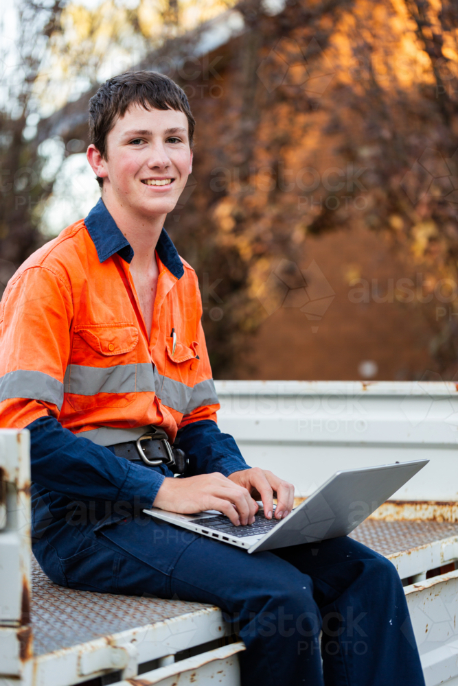 Image of Young teenaged trainee tradie apprentice working on laptop in ...