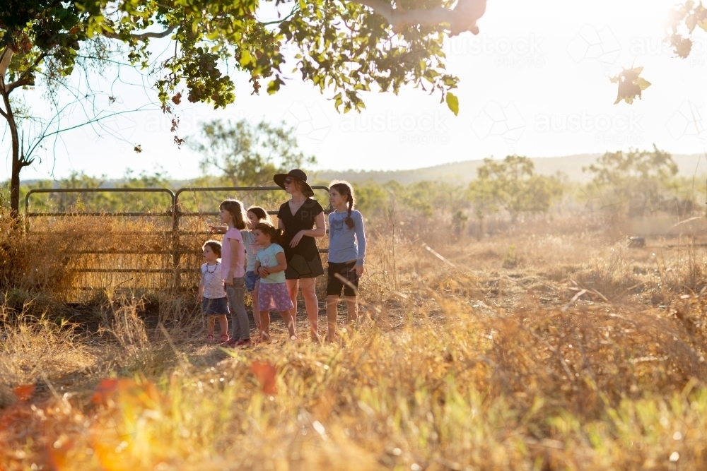 Image of Young woman and children in outback setting - Austockphoto