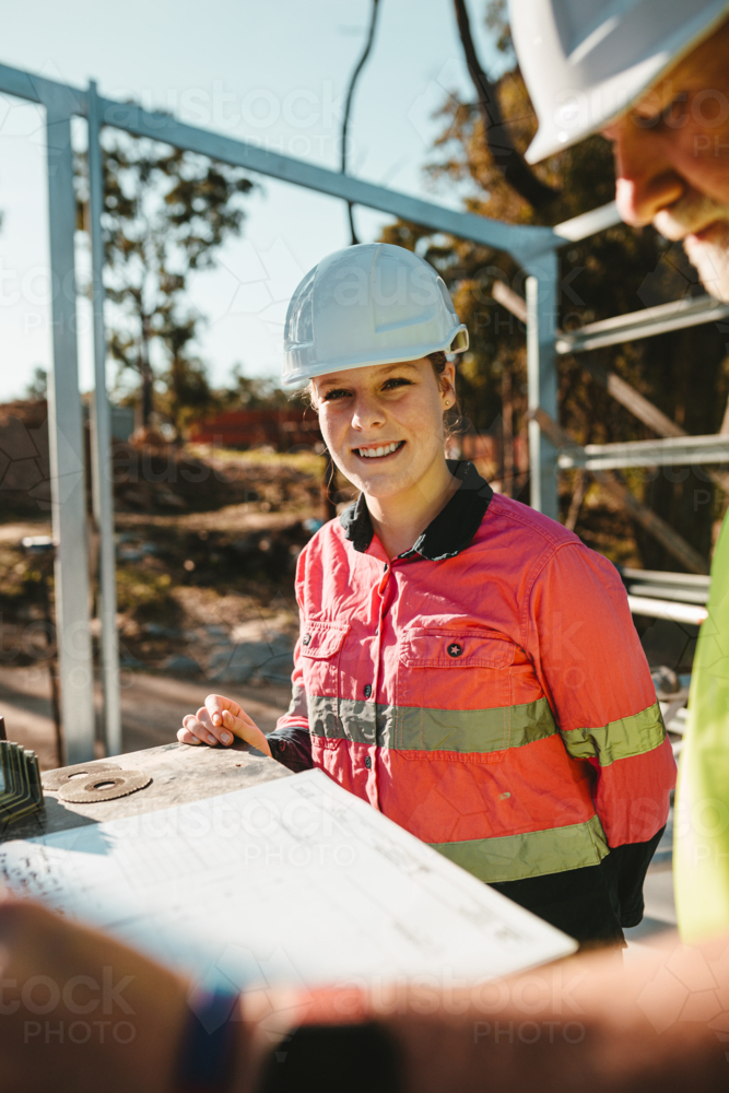 Image of Young woman apprentice standing beside foreman looking at ...