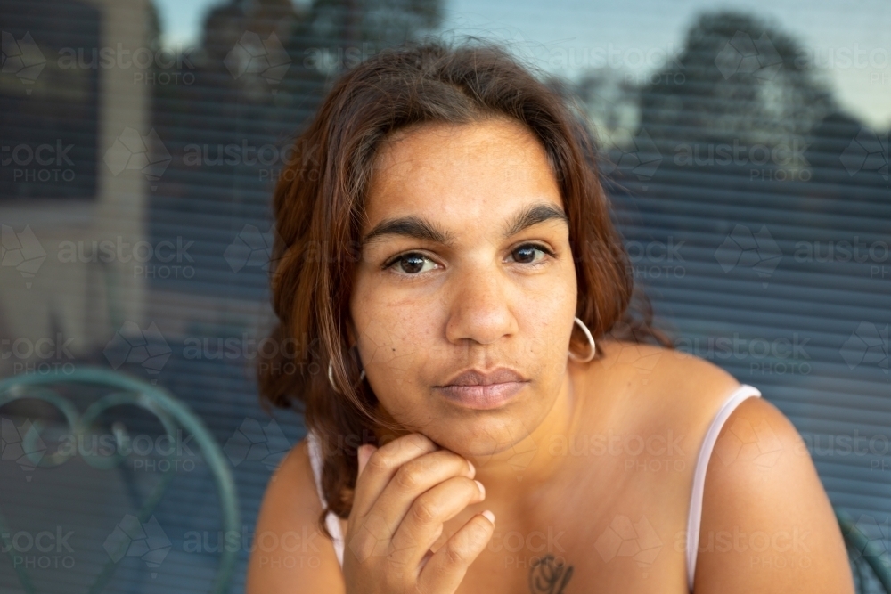Image of young woman by herself outside her own home in small town ...