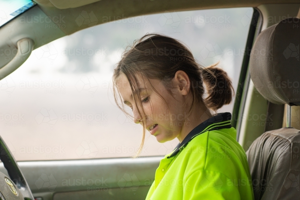 Image of Young woman in vehicle wearing hi-vis - Austockphoto