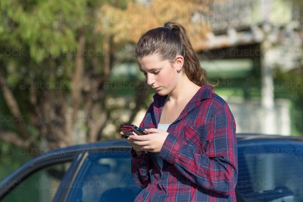 Image of Young woman looking at mobile phone - Austockphoto