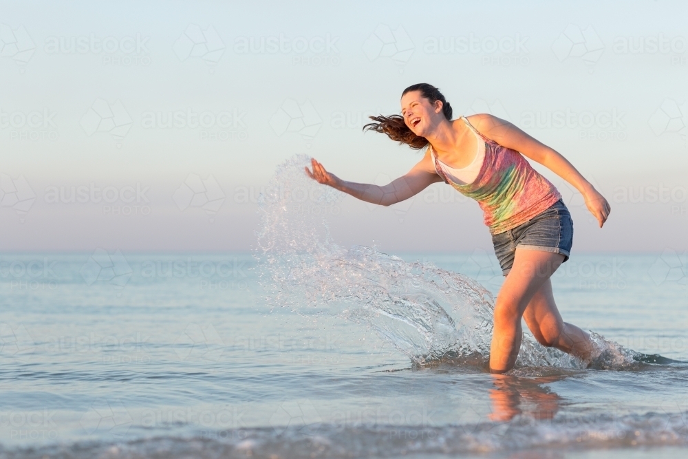 Image of Young woman splashing water - Austockphoto