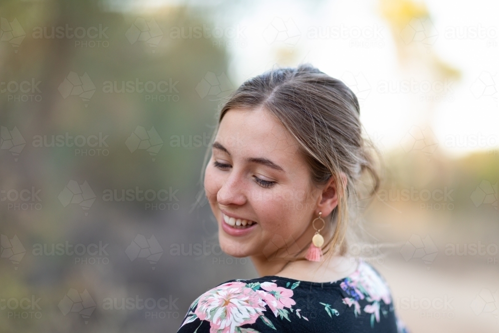 Image of young woman with head turned looking down - Austockphoto