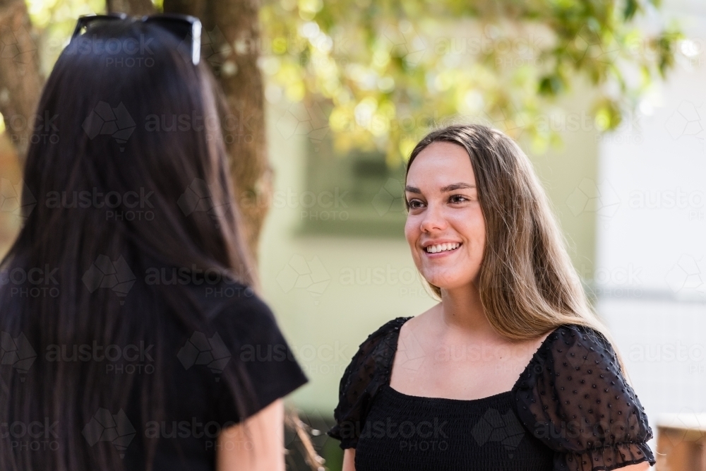 Image of young women talking outside - Austockphoto