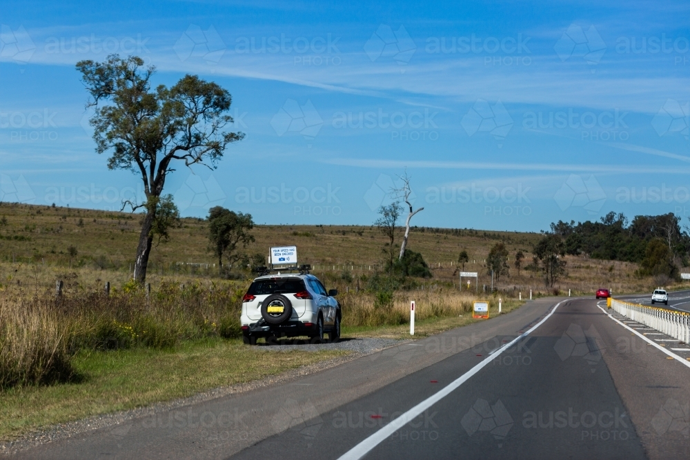 Image of Your speed has been checked sign above police car at the side ...